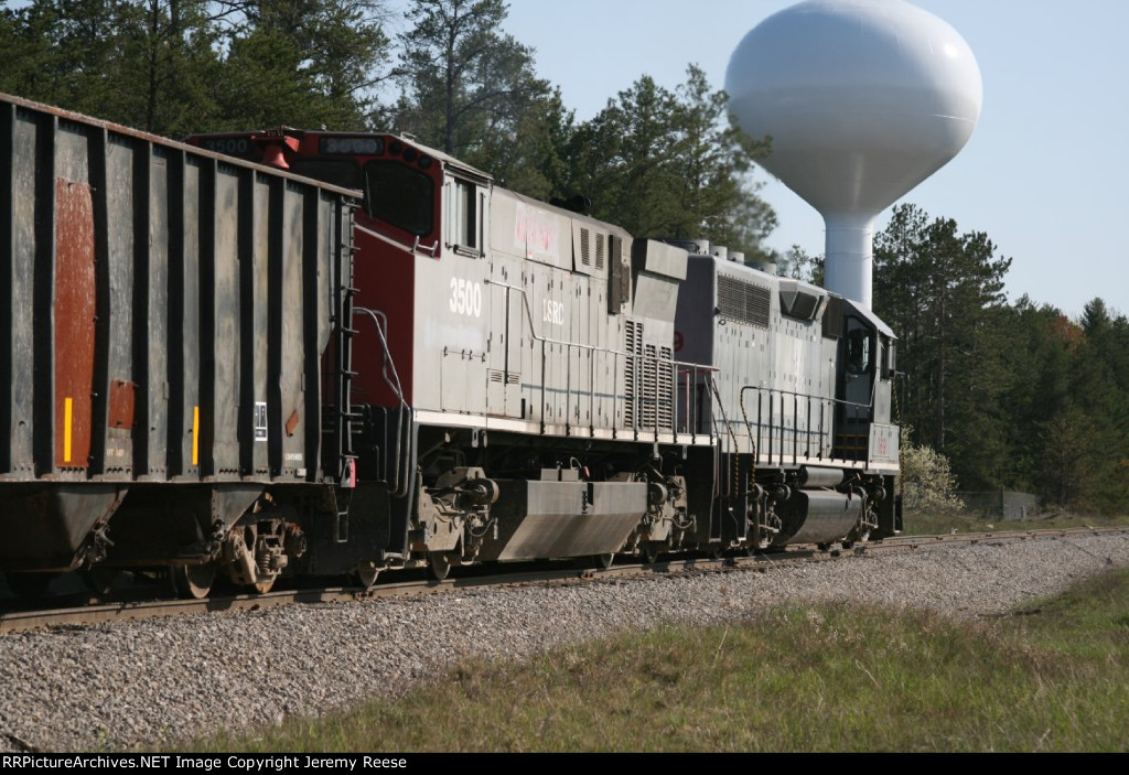 LSRC 1169 leading train south out of town into low sun